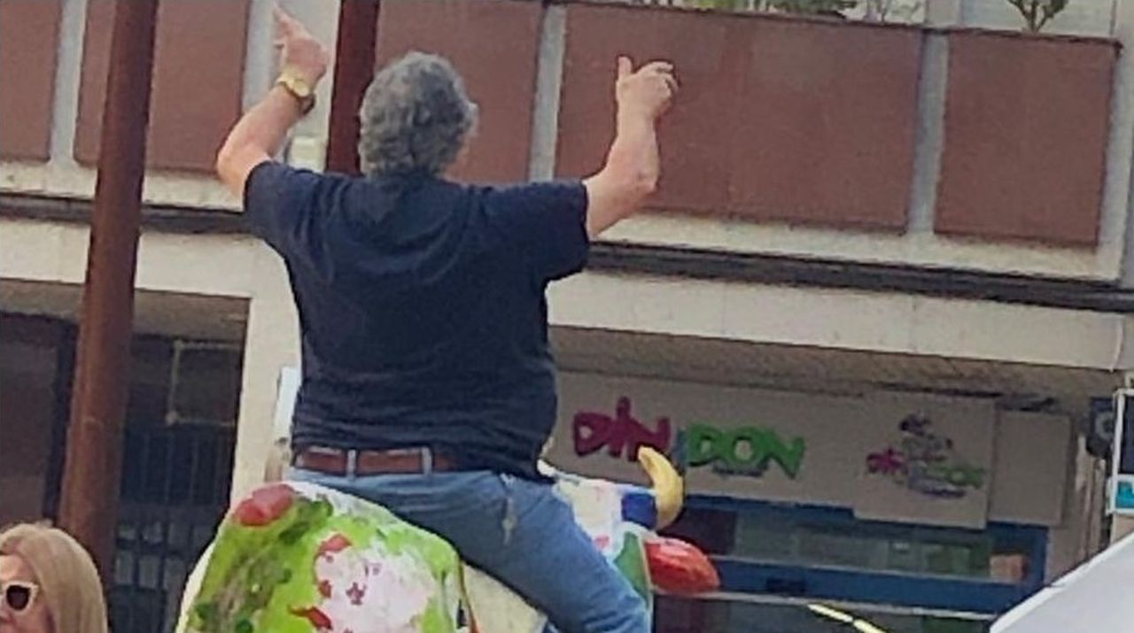 Un hombre se sube a la vaca «Popi» en la Praza Paz Nóvoa de Ourense